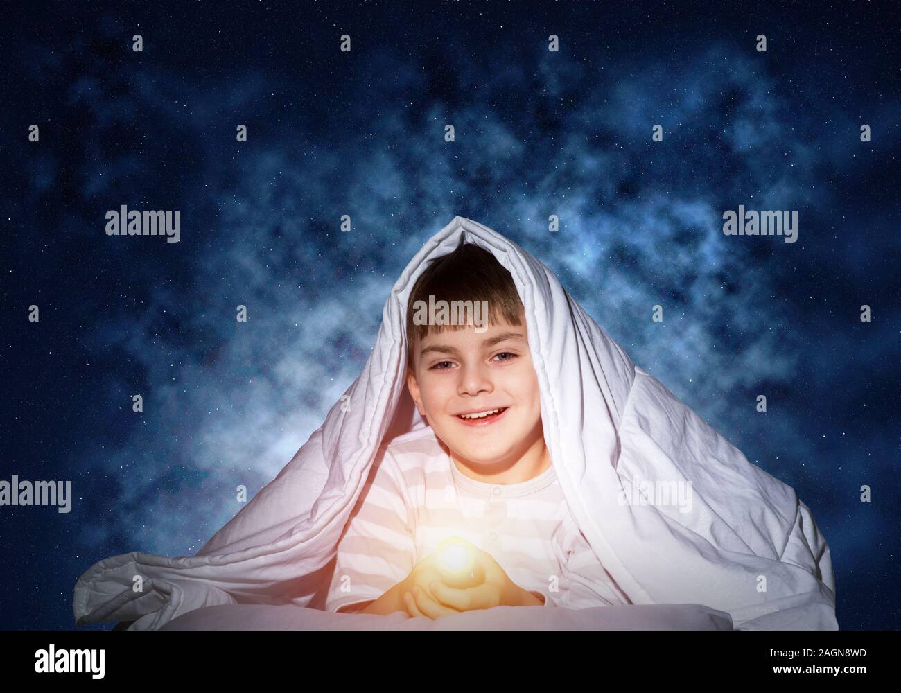 Happy child with flashlight hiding under blanket Stock Photo - Alamy