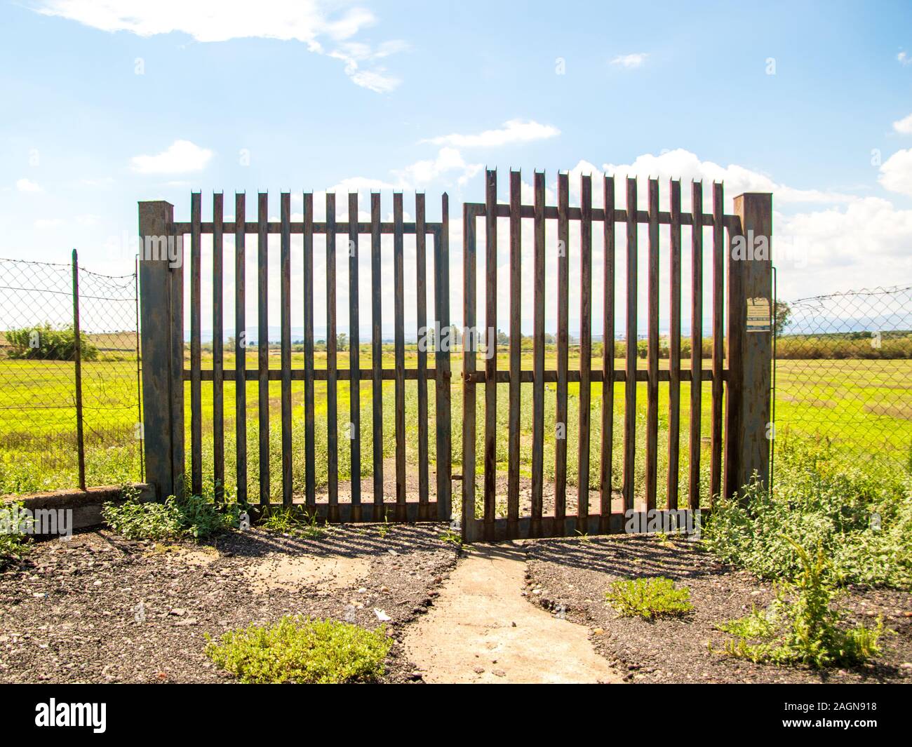 A view through iron gates that lead into an Italian farm Stock Photo ...