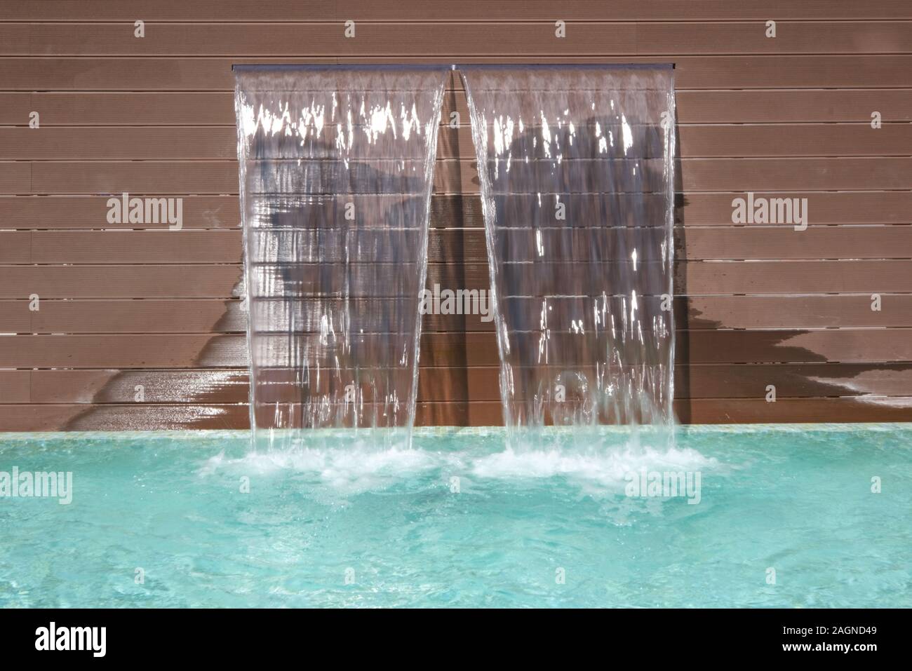 Scenery of water flowing from a wall into the pool Stock Photo - Alamy