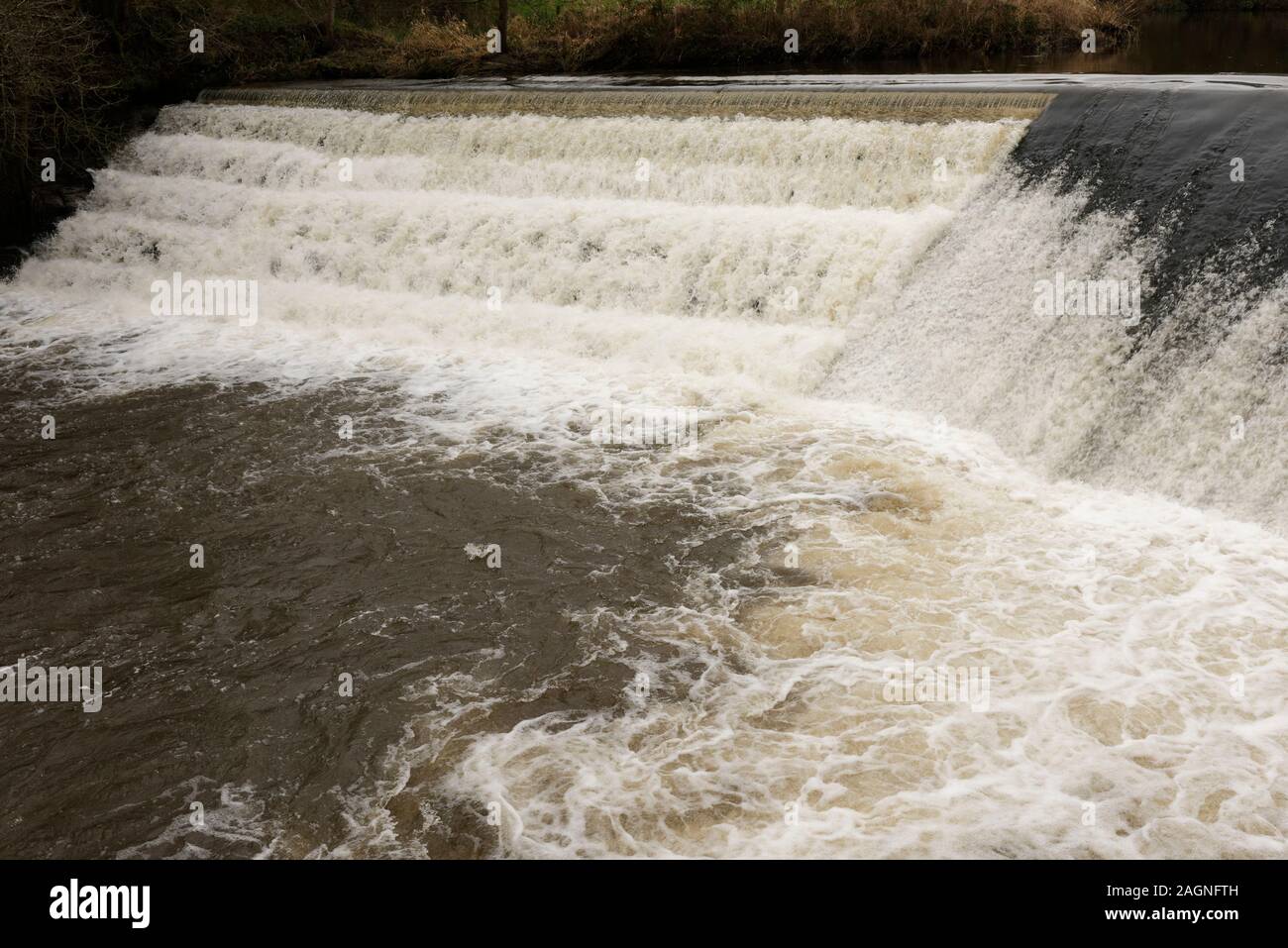 Fast flowing river irwell plunging over weir and aerating river ...
