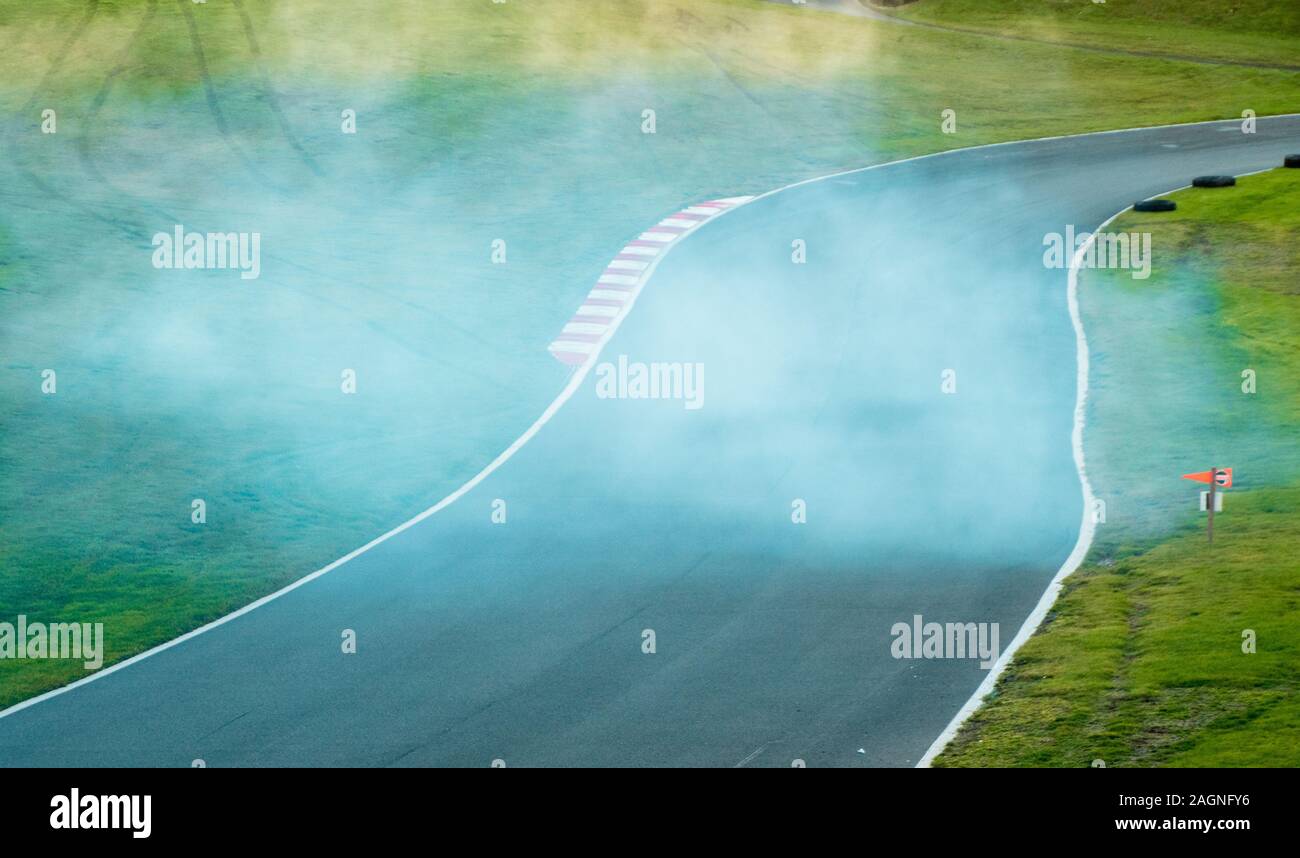 Smoke coming from a rally car at a racetrack, in the UK Stock Photo - Alamy