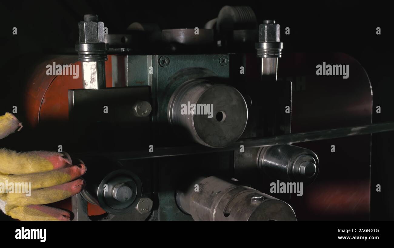 Forge workshop on table. Worker bends the metal rod on the wrought iron ...
