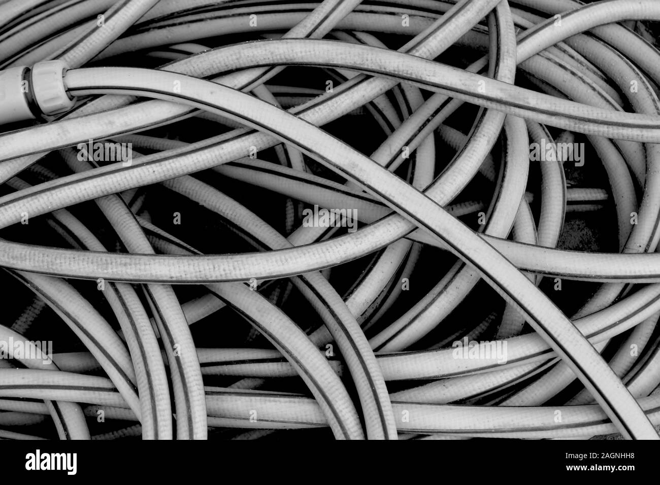 Photo of yellow pile of a tangled long hose or cable wire background ...