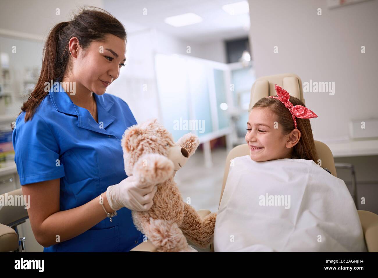 Dentist relaxing child before repairing tooth with teddy bear Stock ...