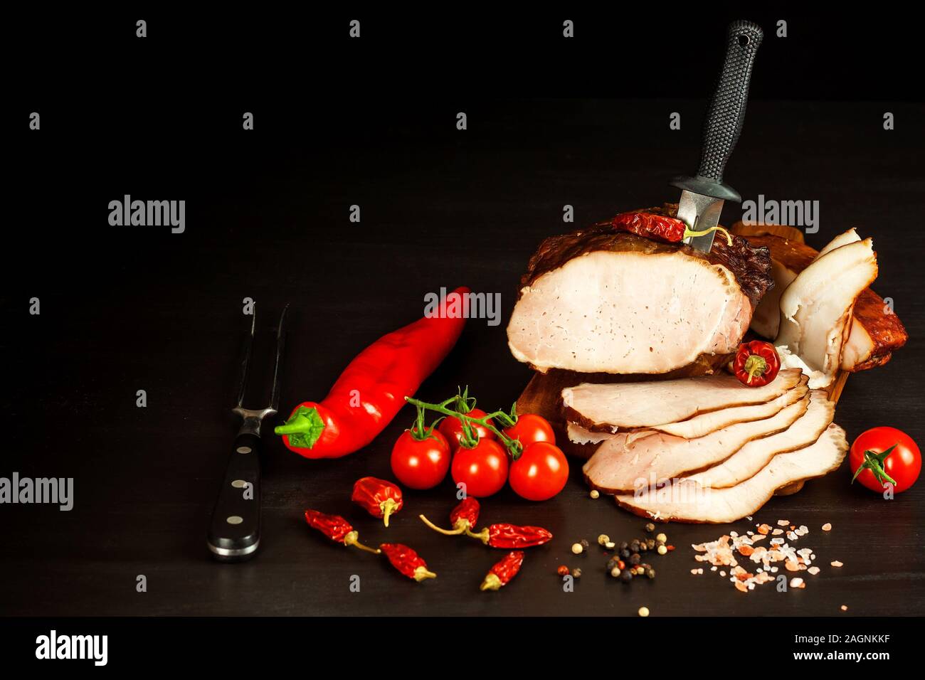 Smoked meat on a kitchen board. Homemade smoked pork with vegetables ...