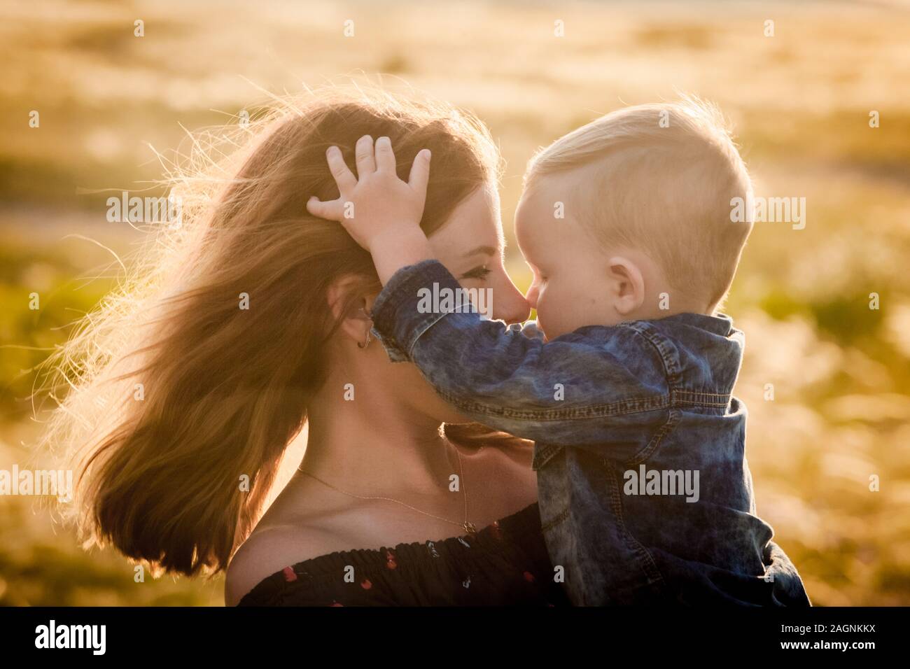 the child hugs the mother by the head Stock Photo - Alamy