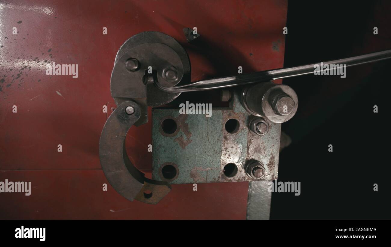 Forge workshop on table. Worker bends the metal rod on the wrought iron ...