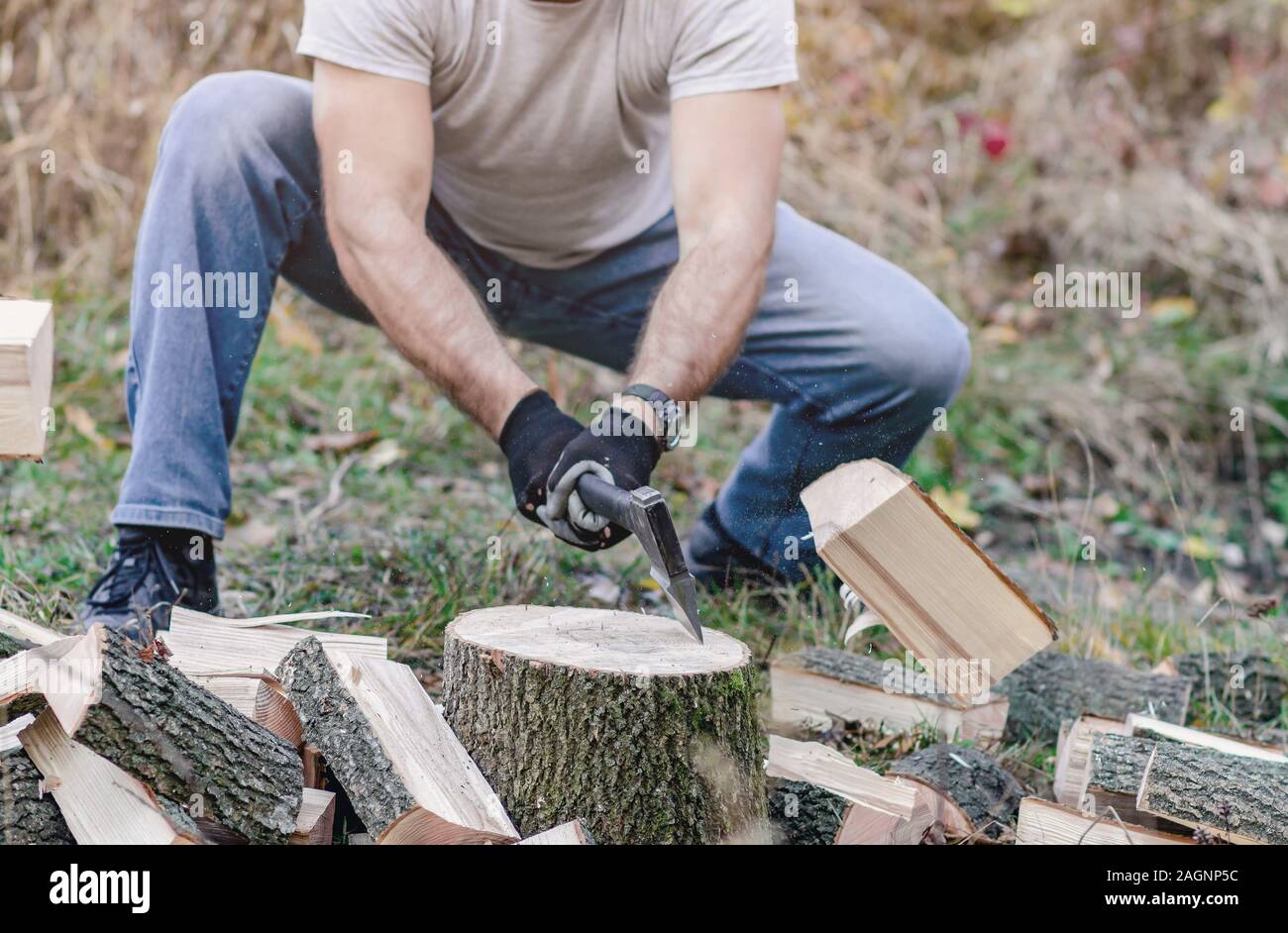 Man chopping wood with an ax, parts of logs scatter to the sides Stock ...