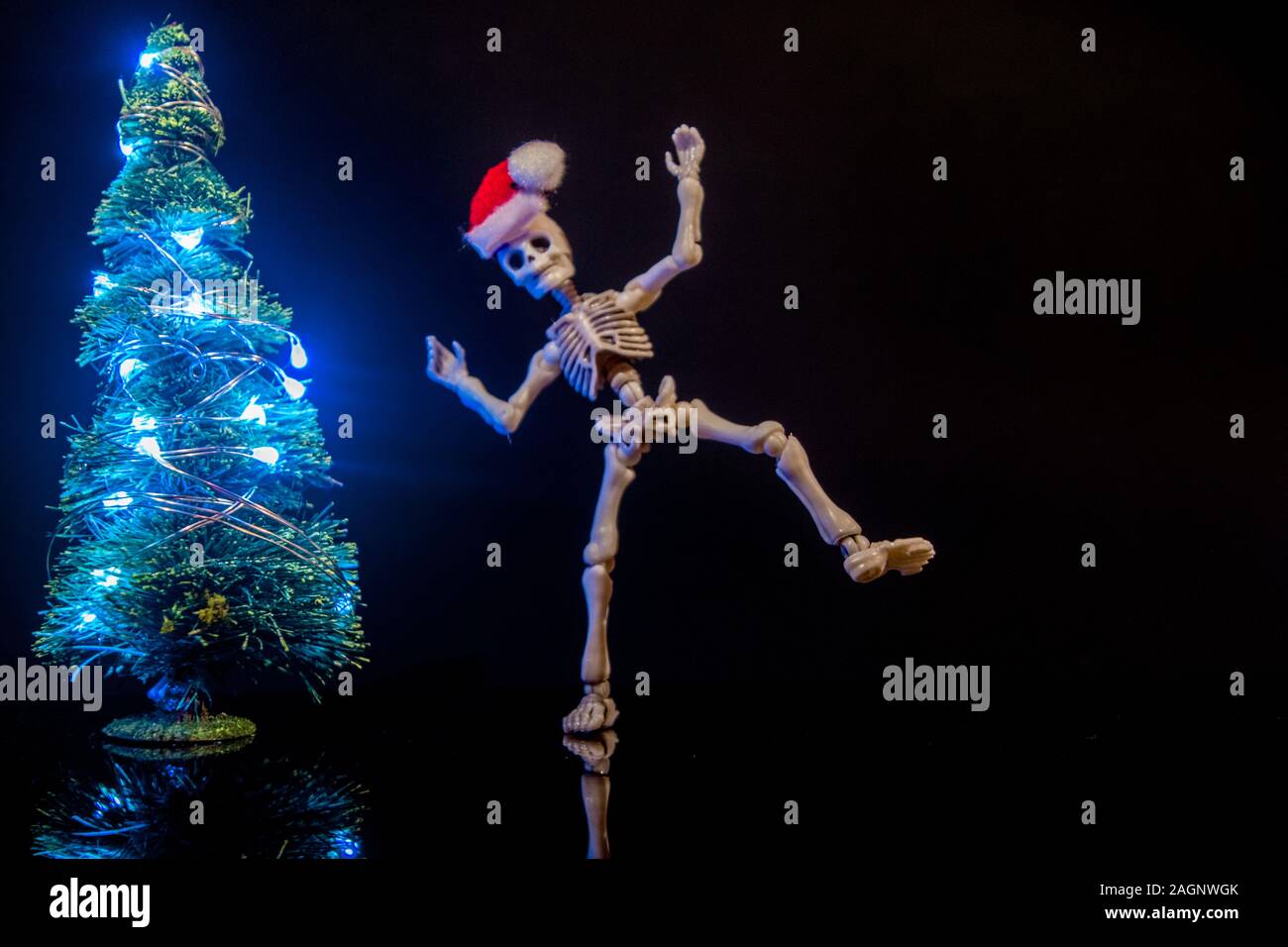 A skeleton dancing around a Christmas Tree with lights Stock Photo - Alamy