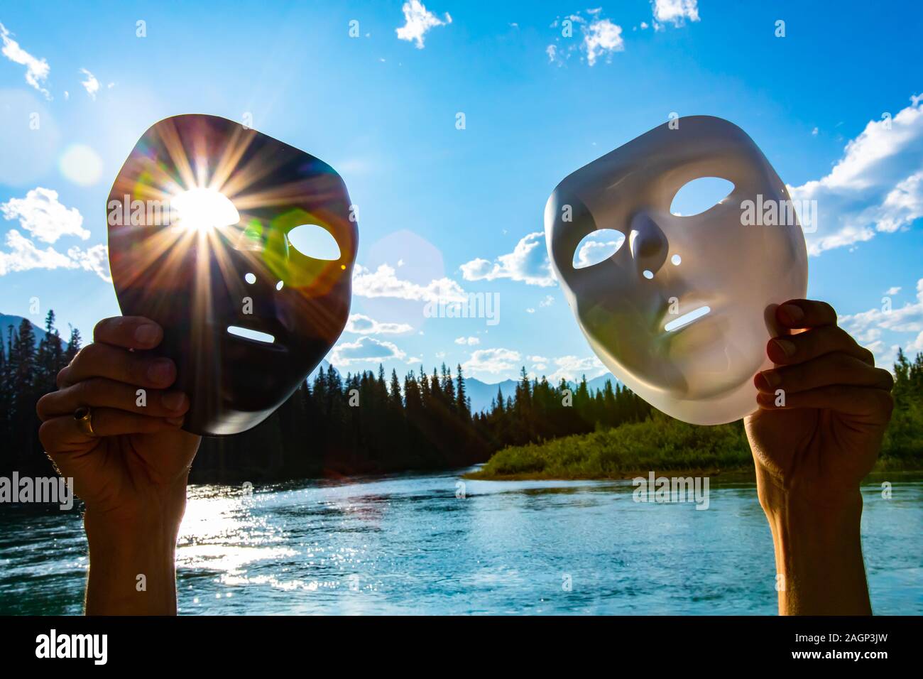 Light and dark concept in nature as a person holds two masks against ...