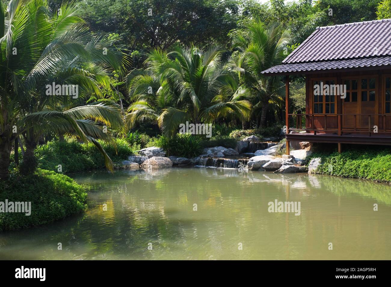 Wooden house beside a pond in a resort Stock Photo - Alamy