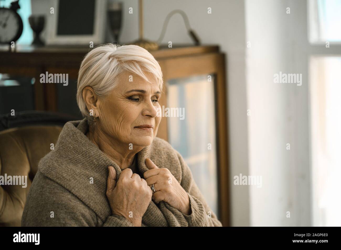 Thoughtful Mature Woman Is Relaxing At Home. Female Is Sitting On The ...