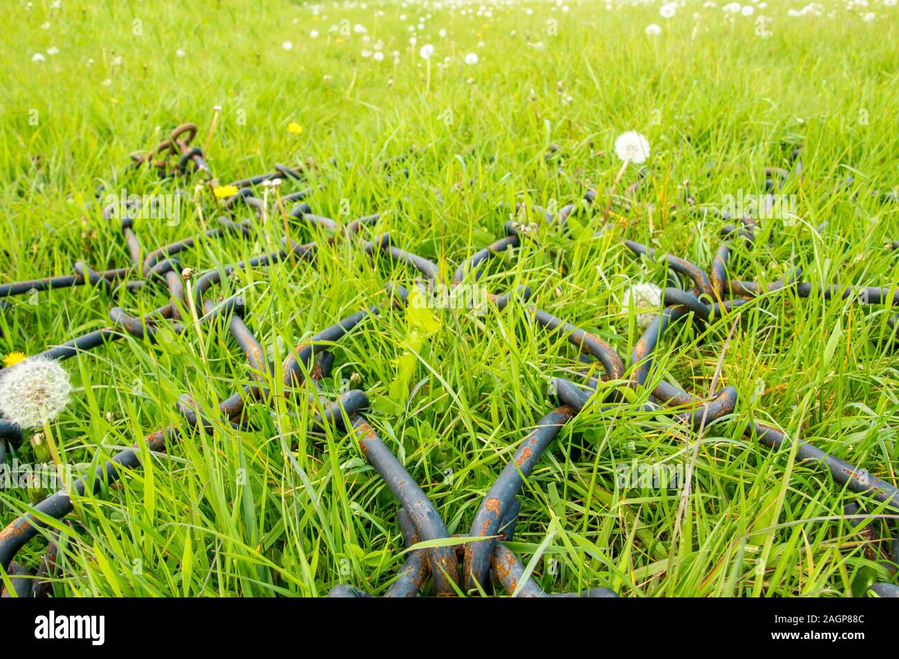 A large and heavy metal piece of agricultural equipment lays in the ...