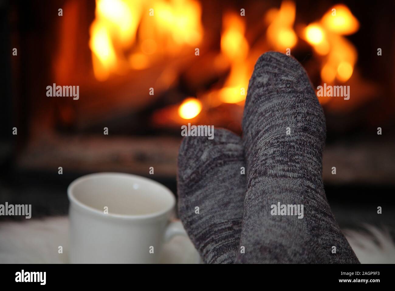Warming feet by a cozy fire Stock Photo - Alamy