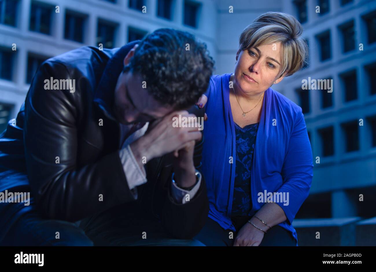 A woman comforts a grieving man Stock Photo - Alamy