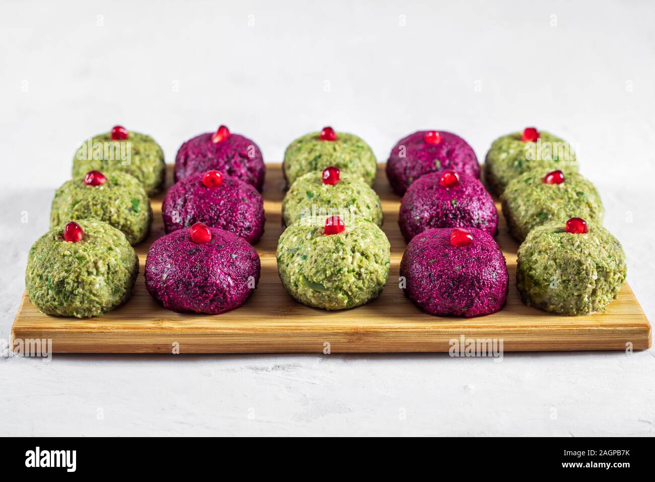 Pkhali with beets and beans on a cutting board on a white background ...