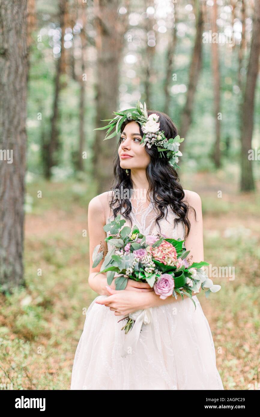 beautiful bride in nature in a coniferous forest in a wreath on her ...