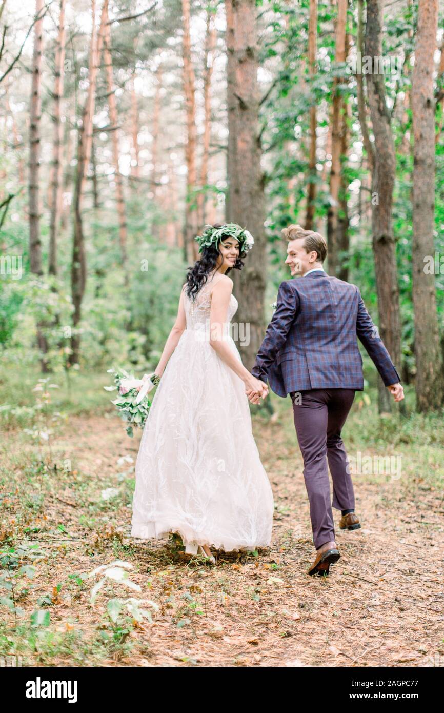 Back view of stylish rustic couple of newlyweds on their wedding day ...