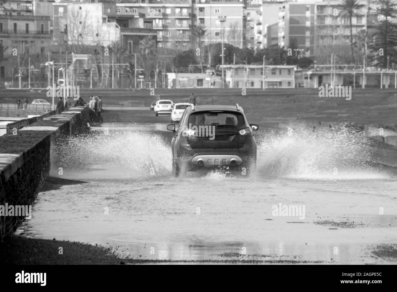 A car driving fast through a large puddle Stock Photo - Alamy