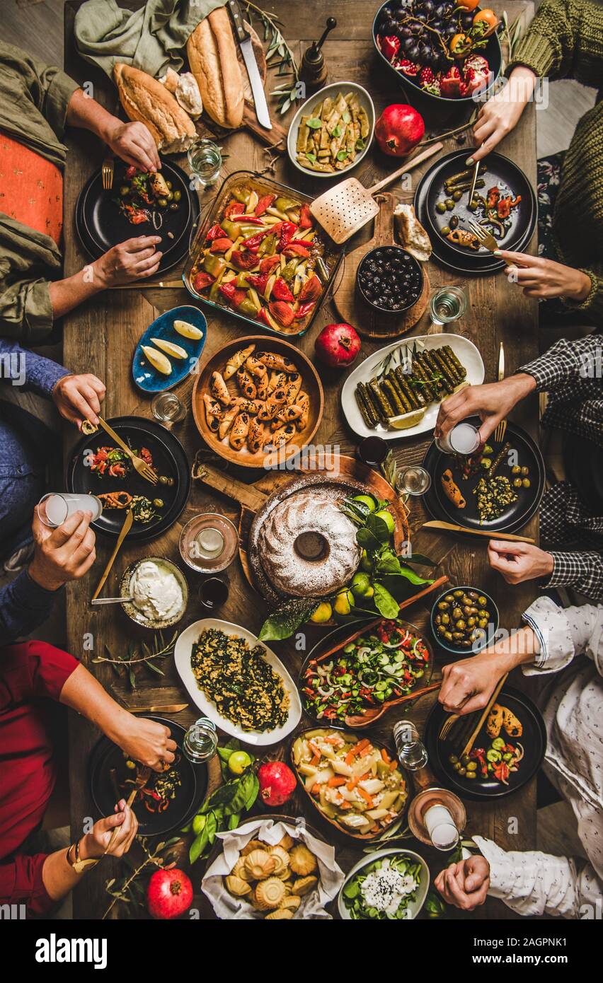 Turkish family feasting at table with traditional foods and raki Stock ...
