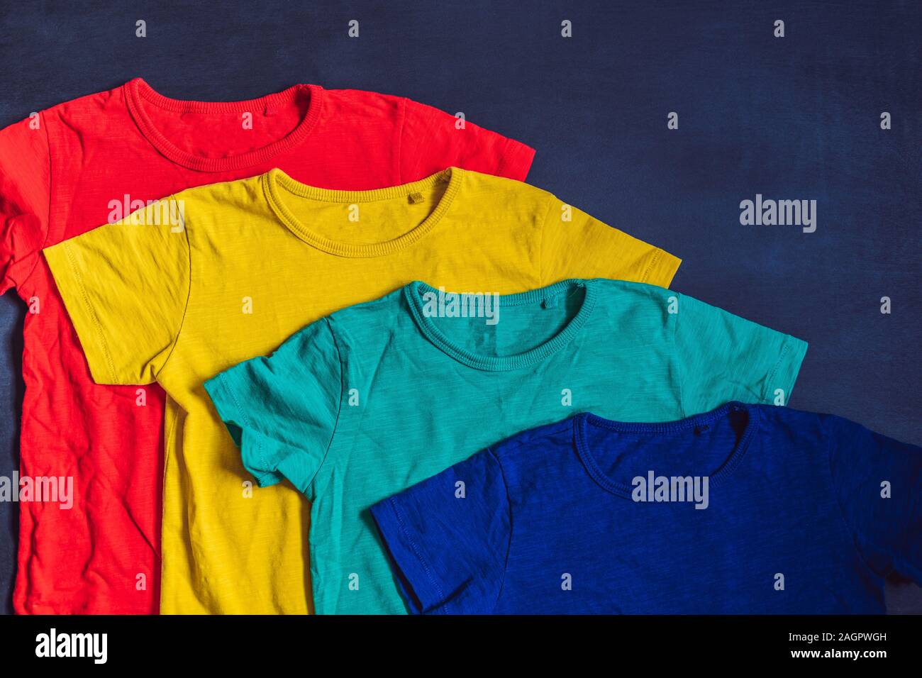 Colorful collection of t-shirts on wooden background Stock Photo - Alamy