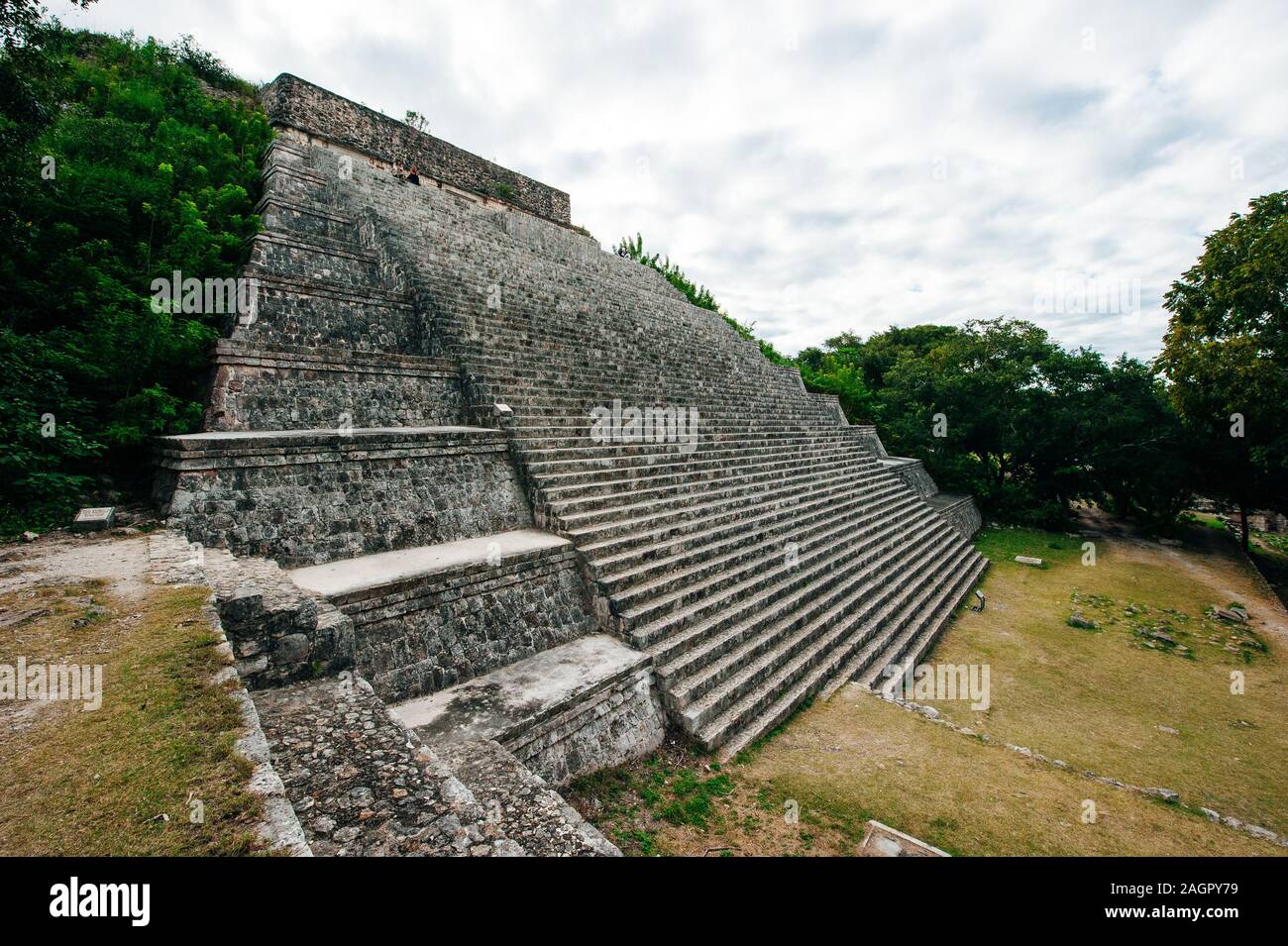 Ancient mayan wall with arches with green garden around in Uxmal ...