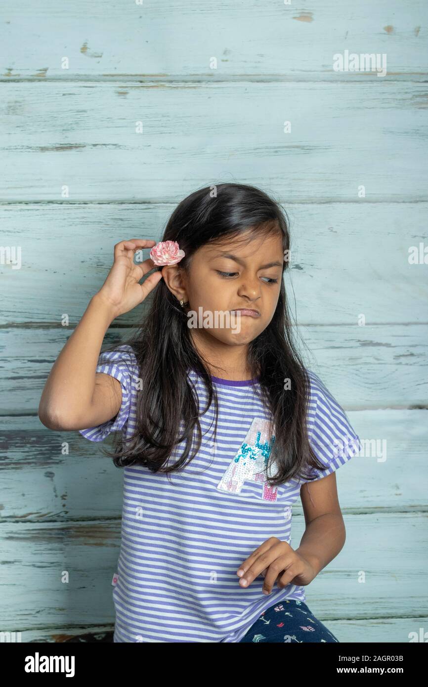 Angry girl with a pink rose in her hand Stock Photo - Alamy