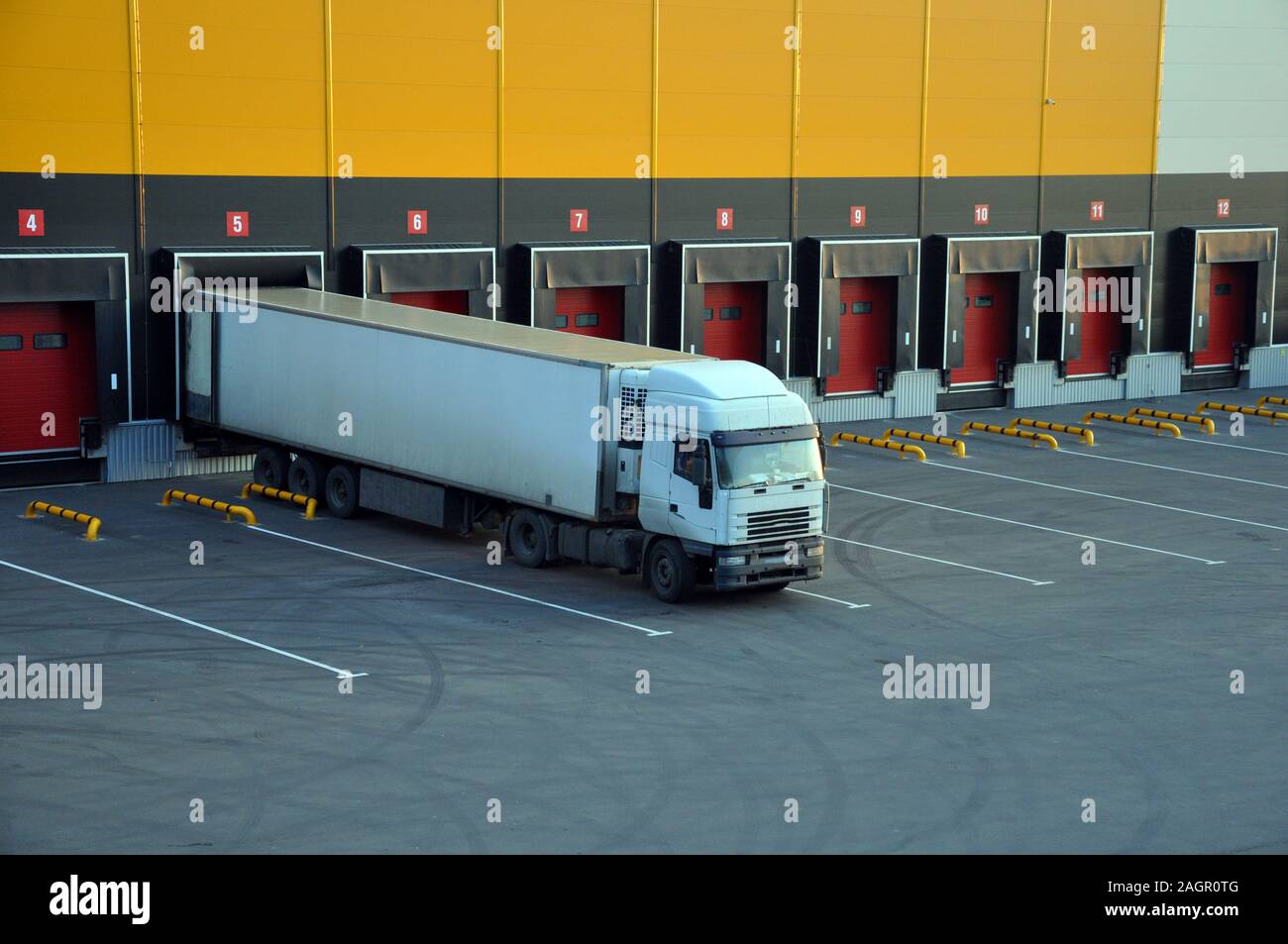 Unloading trucks at a modern warehouse complex. Logistics Stock Photo ...