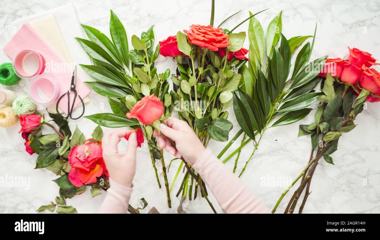Flat lay. Florist running red roses for bouquet arrangement Stock Photo ...