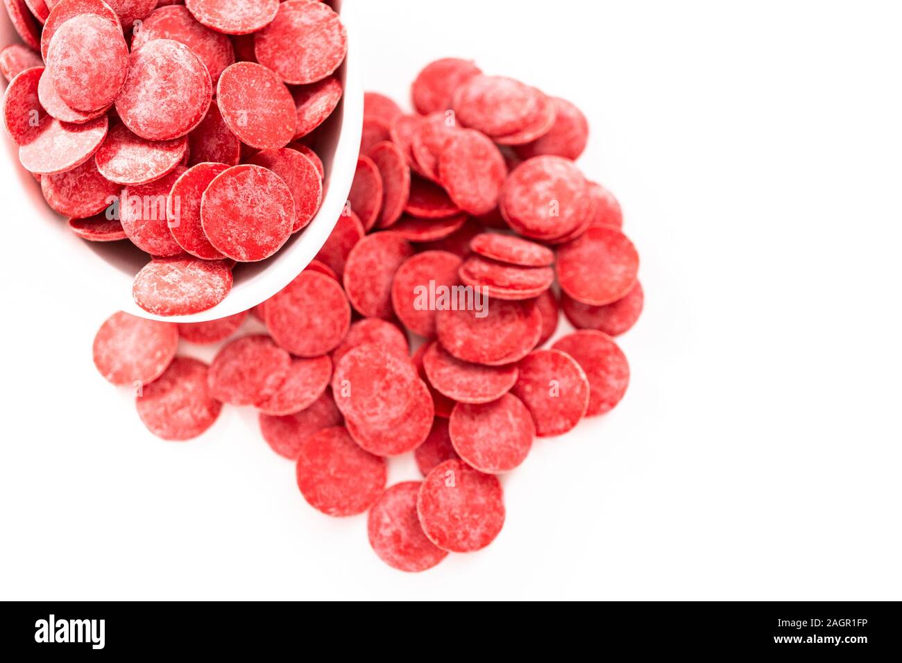 Red round chocolate chips for melting chocolate shapes on a white ...