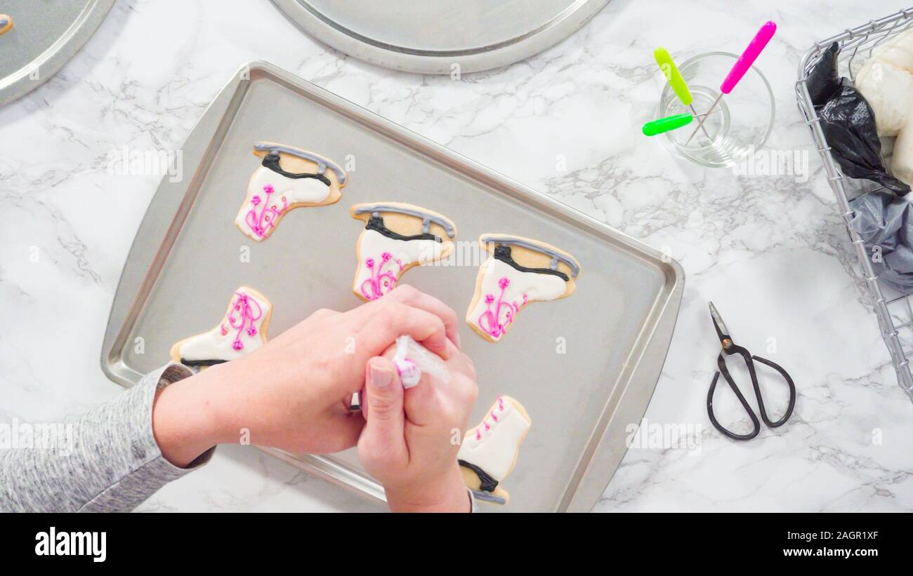 Flat lay. Icing figure skate shaped sugar cookies with royal icing ...