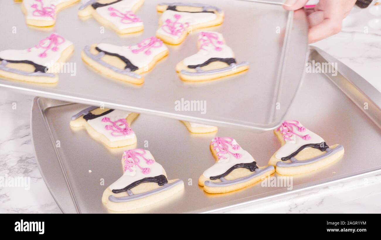 Brushing edible glitter on iced figure skate sugar cookies Stock Photo ...
