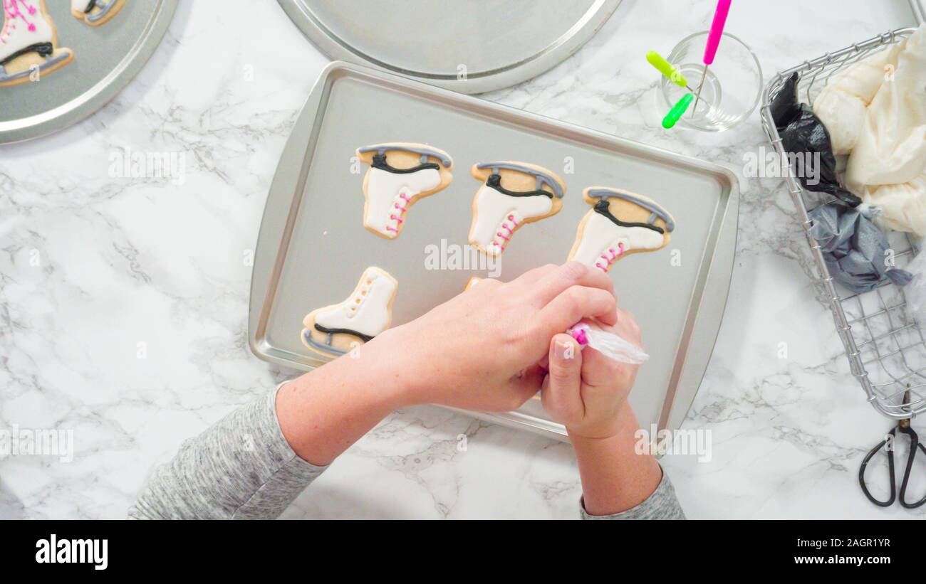 Flat lay. Icing figure skate shaped sugar cookies with royal icing ...