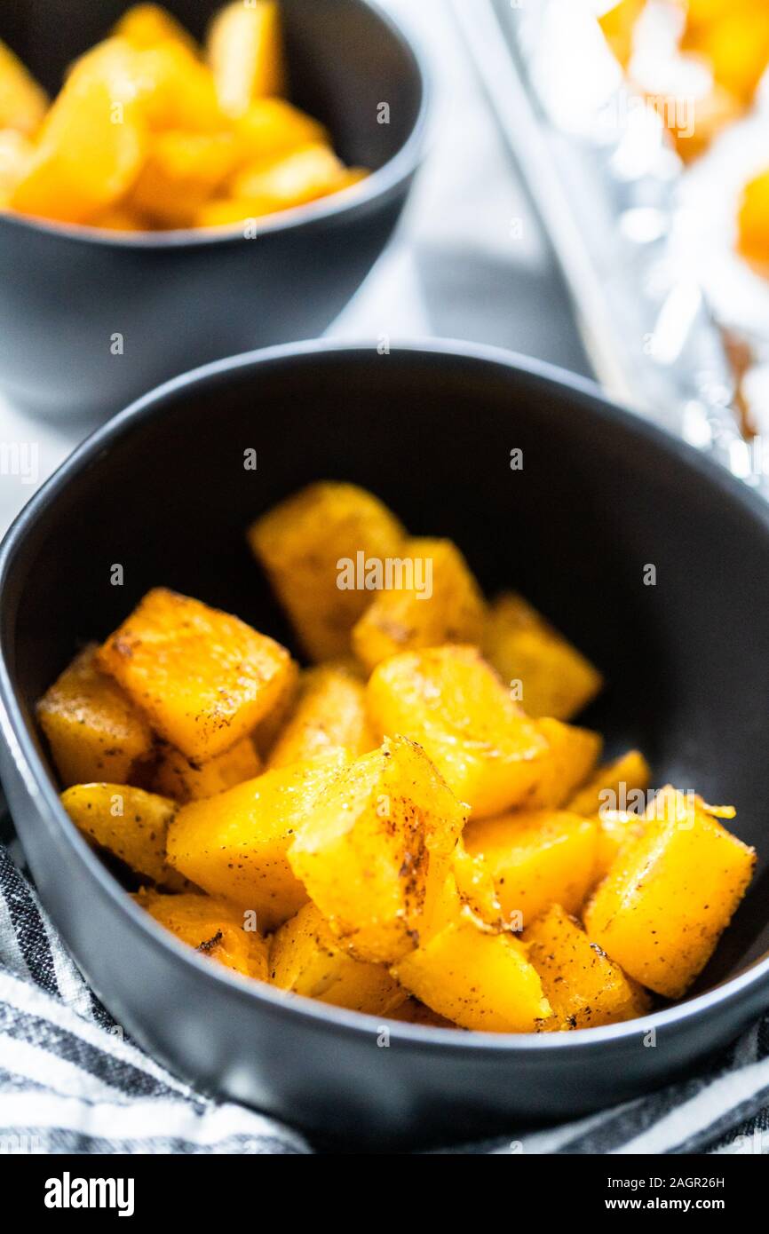 Roasting butternut squash with salt and pepper in olive oil Stock Photo ...