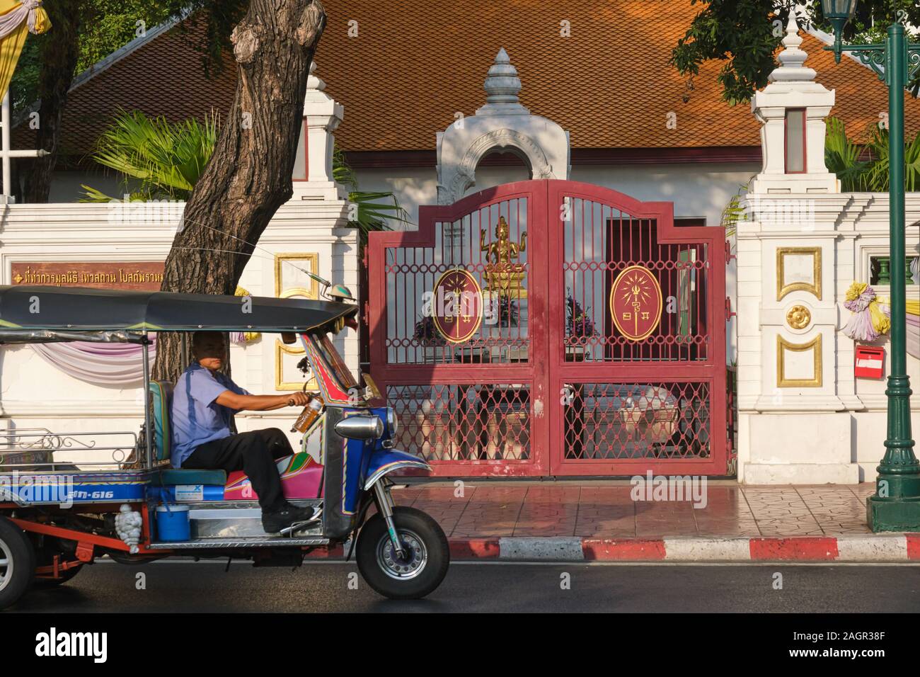 A tuk-tuk (three-wheeled taxi) passes the Thai Brahmin Temple (Bot ...