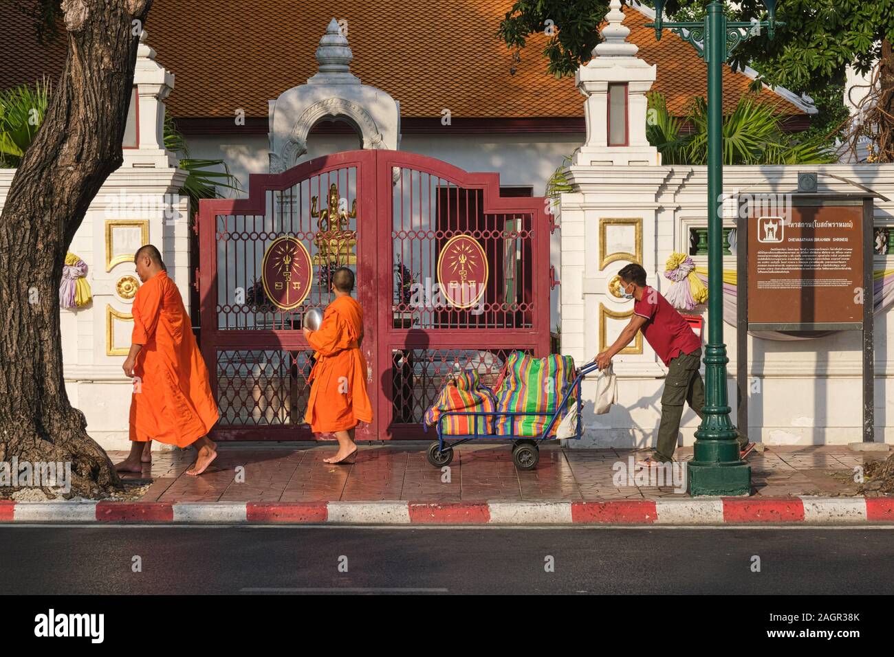 Buddhist monks on their morning alms round passing the Thai Brahmin ...