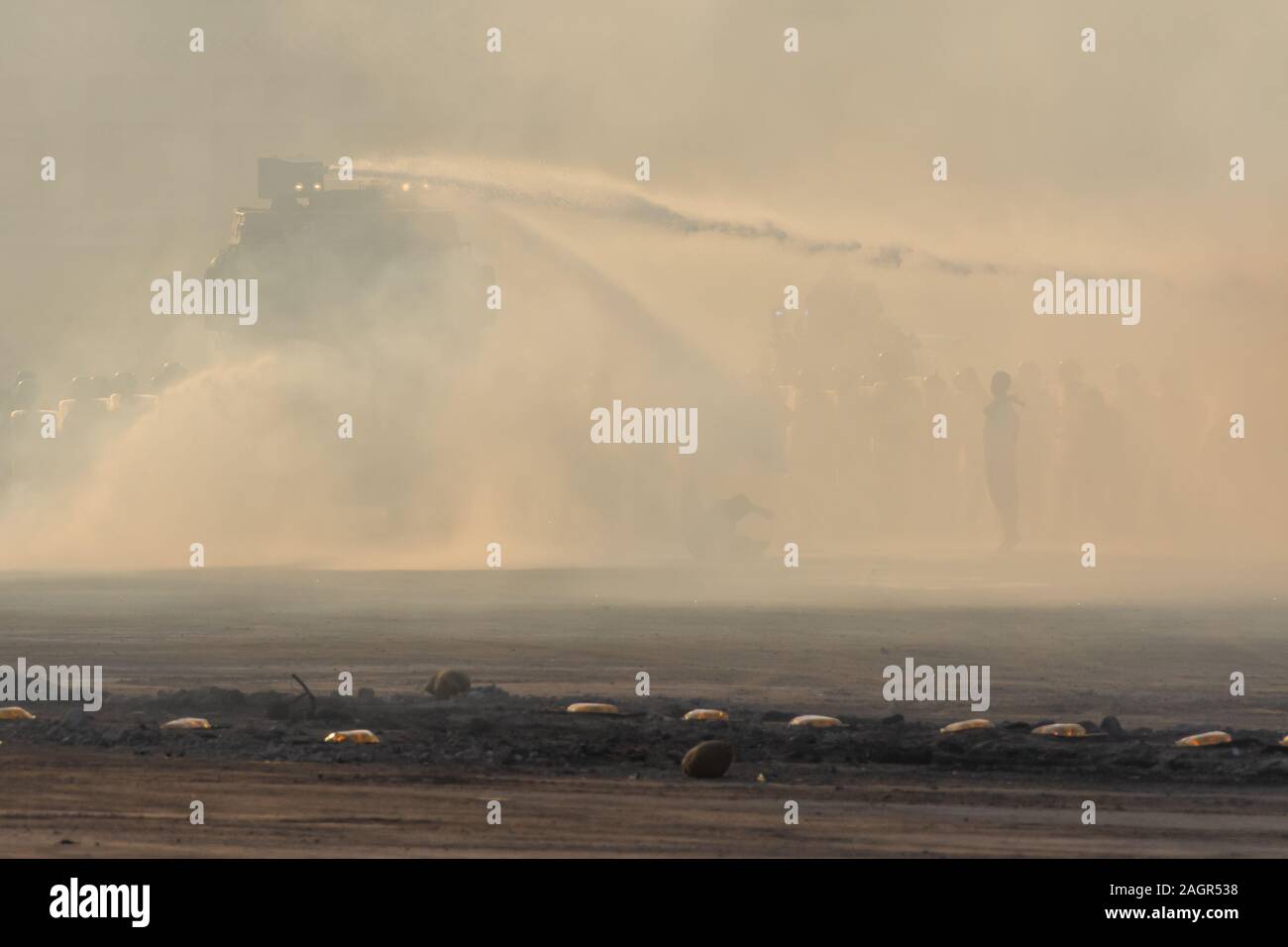 Military police riot response to a protest with tear gas, smoke, fire ...