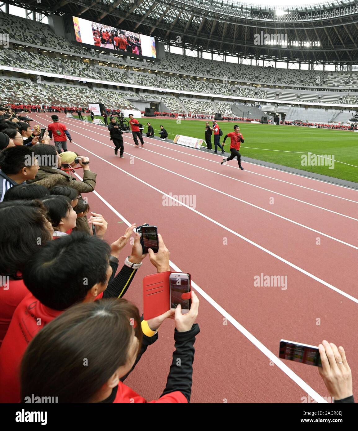 People take photos of sprinter Yoshihide Kiryu during the first run on ...