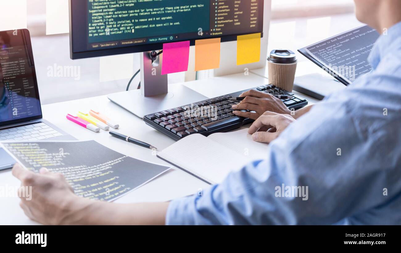 Pensive programmer working on on desktop pc programming code ...