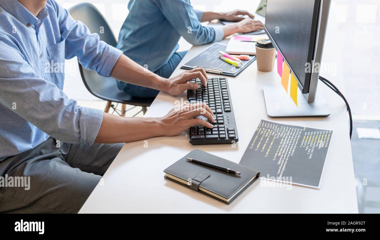 Young startup Programmers Sitting At Desks Working On Computers screen ...