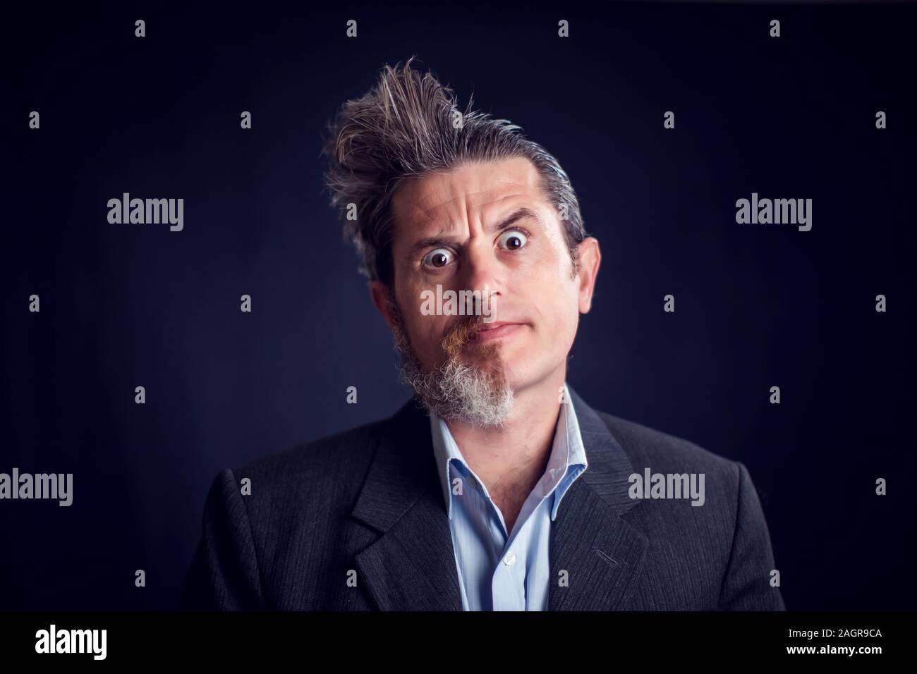 Half bearded funny man wearing suit in front of black background ...
