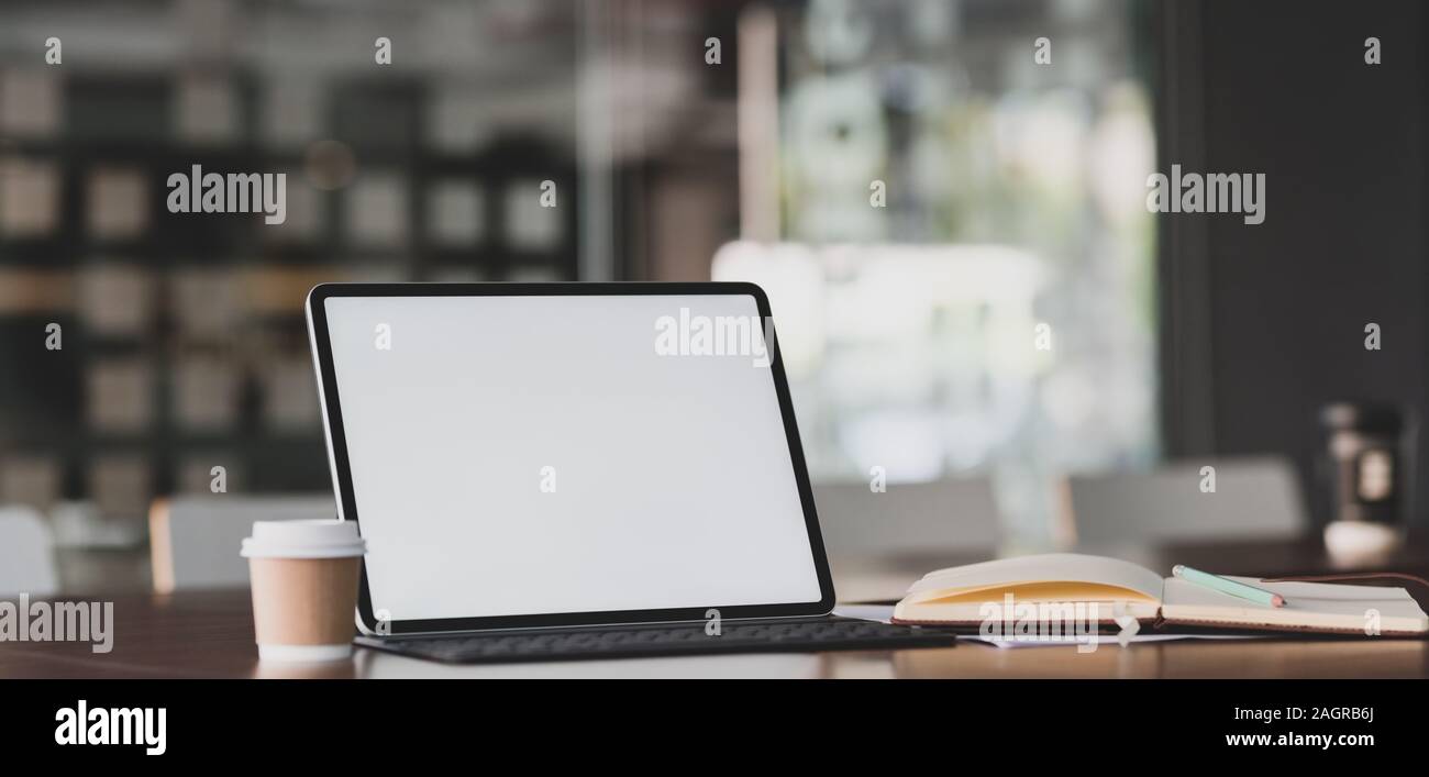 Close-up view of modern office room with blank screen tablet with ...