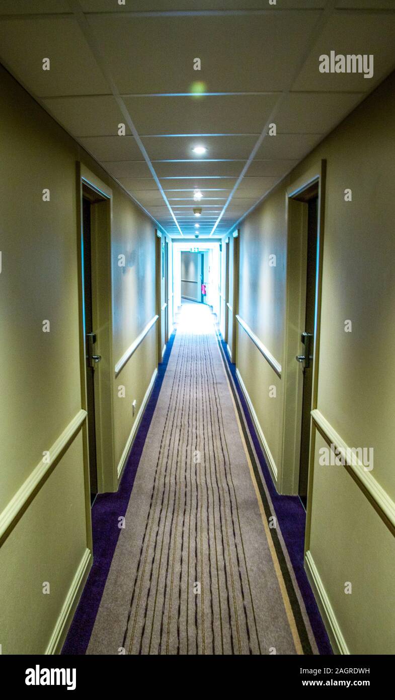 A view along a long corridor within a hotel Stock Photo - Alamy