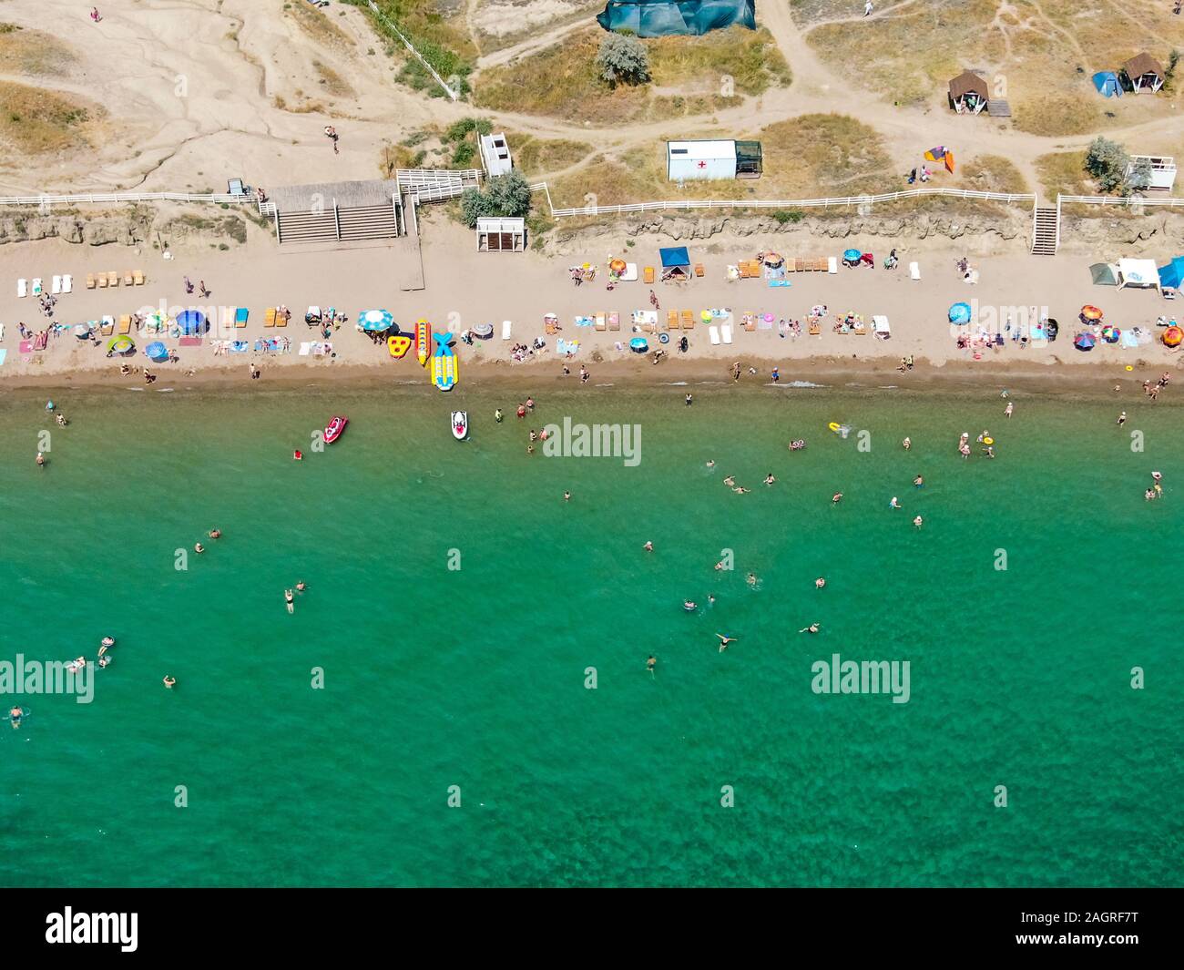 Bird's-eye view. Sea beach people swimming sunbathing relaxing. Human ...