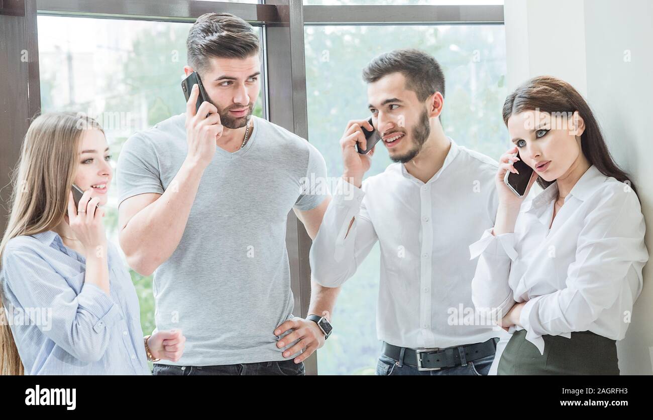 Four young employees Two men and two women employees communicate in a ...