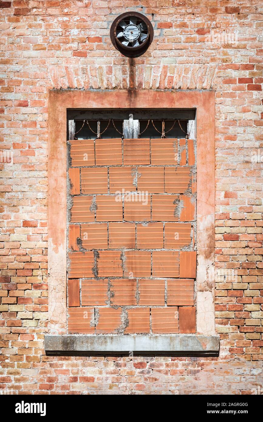 Front view of brick building, walled window and fan Stock Photo - Alamy