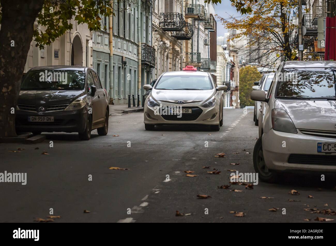 TBILISI, GEORGIA. November 23, 2019. A typical white taxi cab riding ...