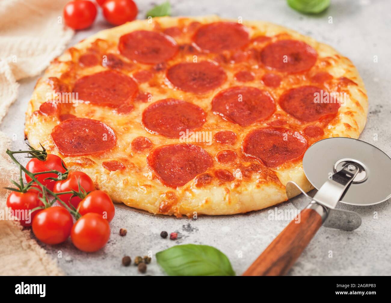 Fresh round baked Pepperoni italian pizza with wheel cutter, tomatoes ...