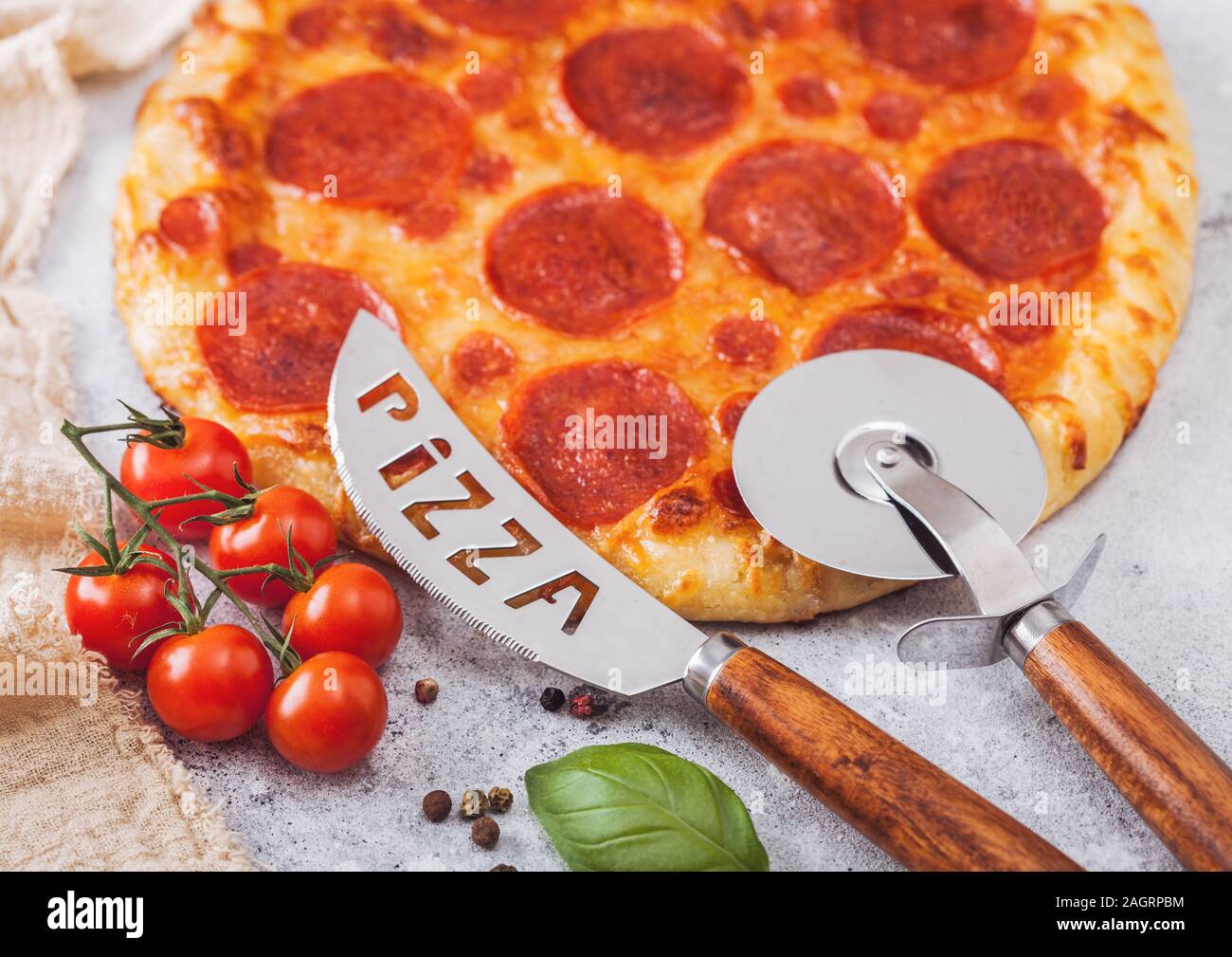 Fresh round baked Pepperoni italian pizza with wheel cutter and knife ...