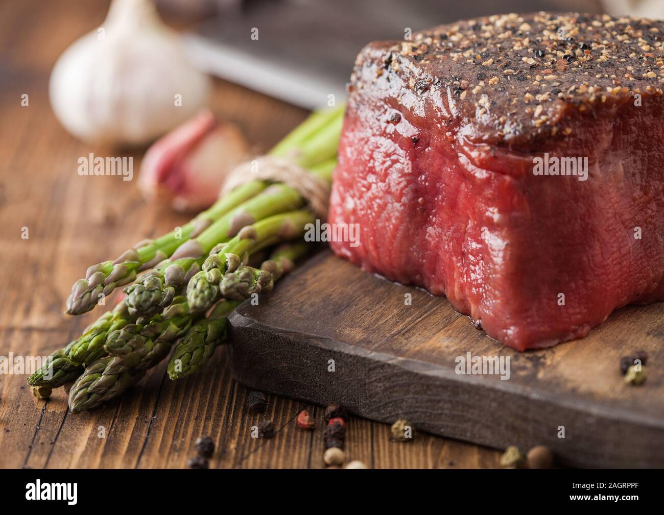 Slice of Raw Beef Topside Joint with Salt and Pepper on wooden chopping ...